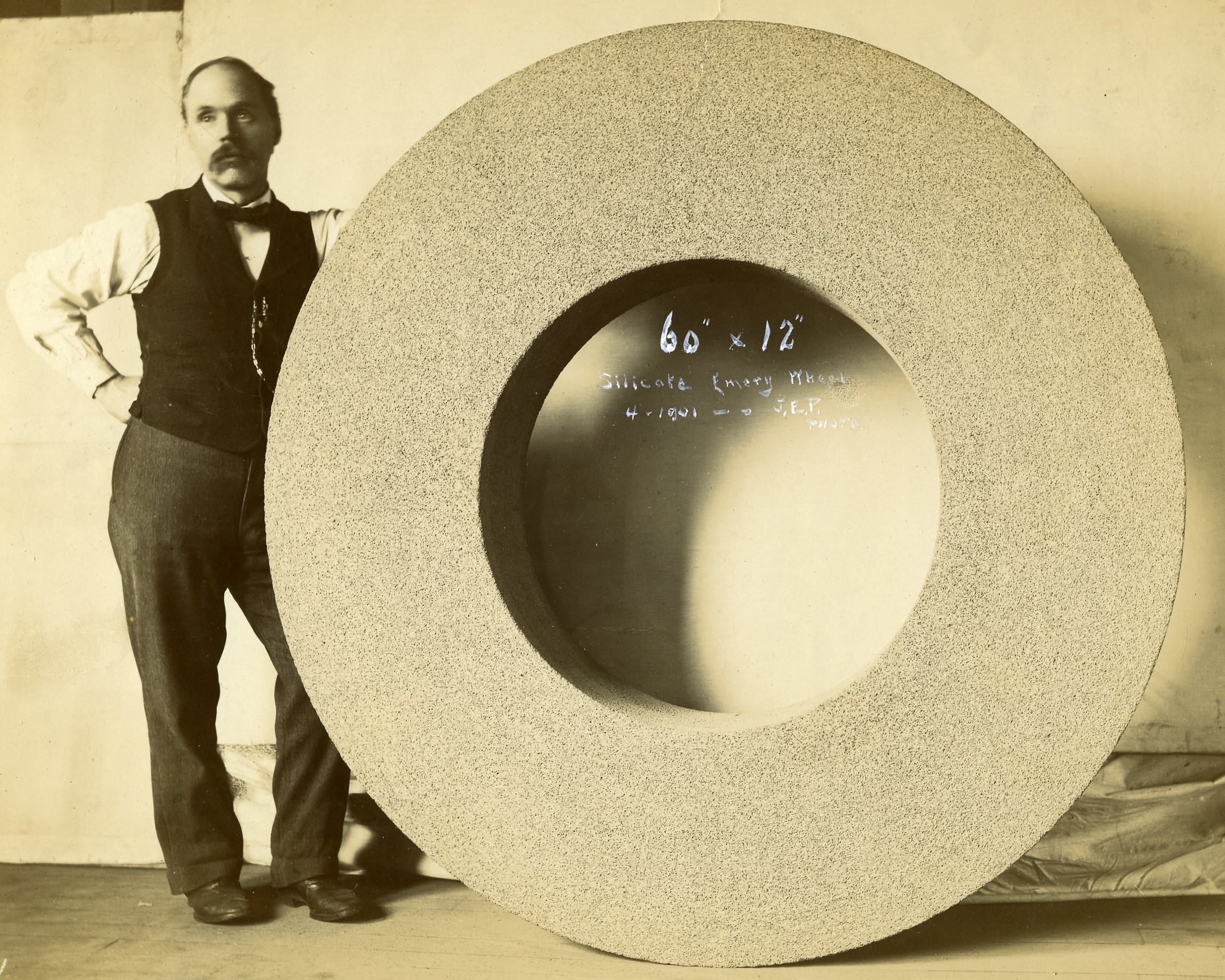 Norton Company Johnnie Robinson standing next to Emery Wheel ...